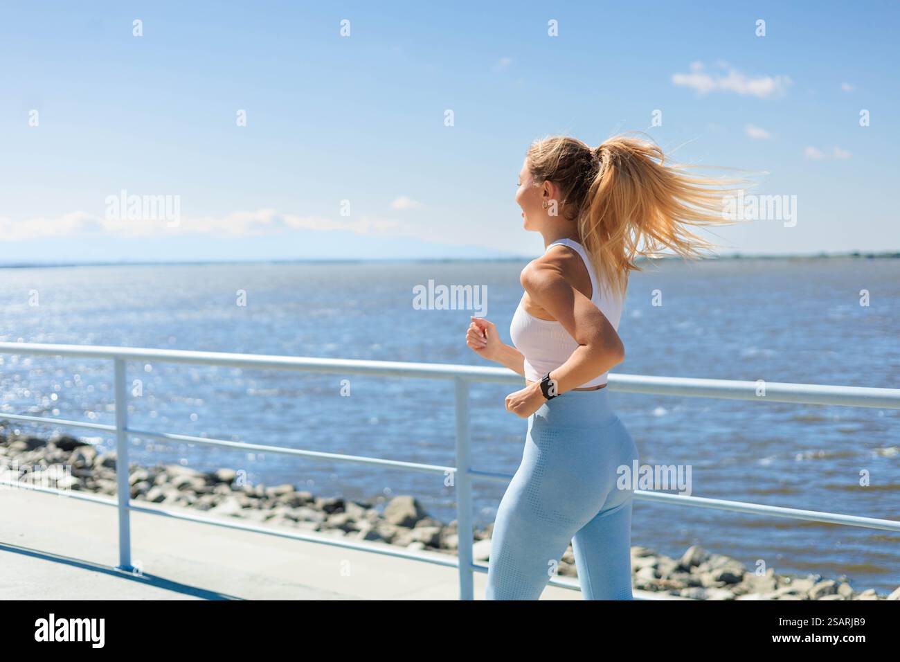 Female jogger running on embankment hi-res stock photography and images ...