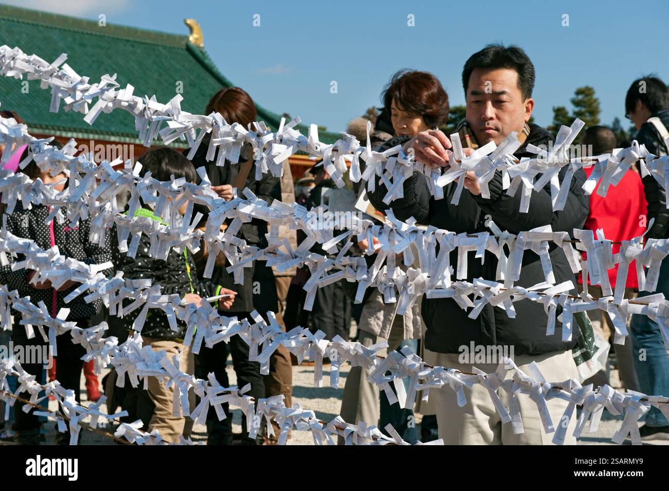 People tying their "omikuji" (good or bad luck paper oracle) to a ...