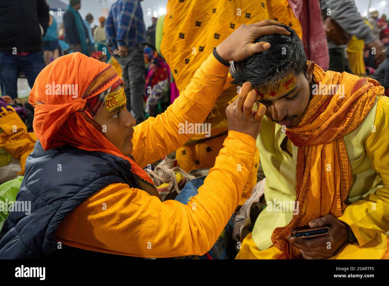 A Hindu devotee gets sacred marks painted on his forehead by a priest ...