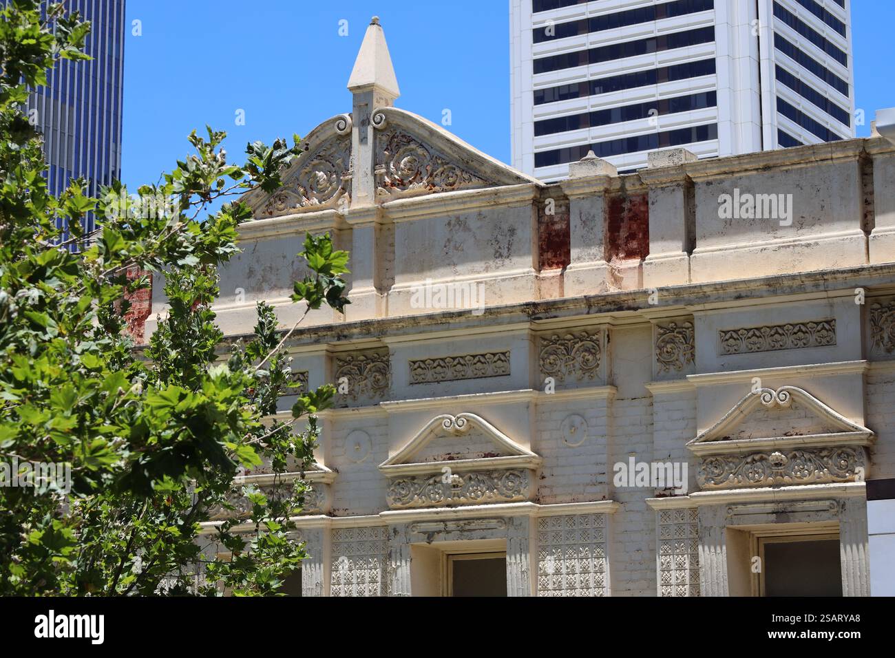 historic building nestled between modern skyscrapers in sunshine Stock ...