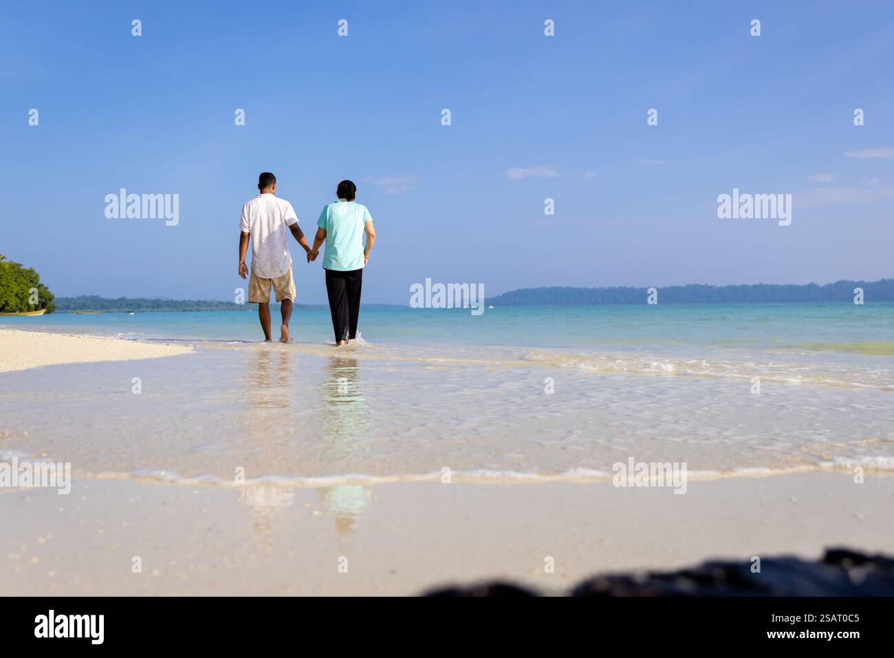 married couple romantic walk with holding hands strolling along beach ...