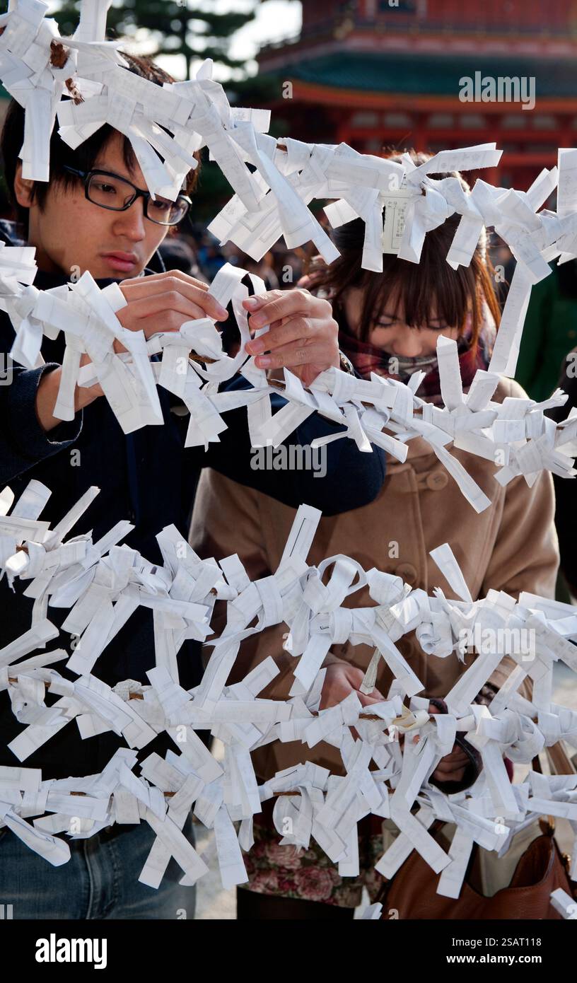 People tying their "omikuji" (good or bad luck paper oracle) to a ...