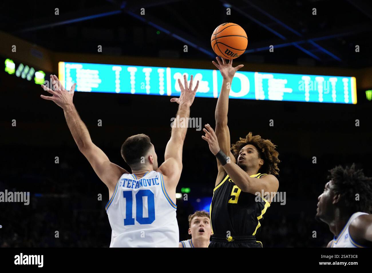 Oregon guard Keeshawn Barthelemy, center, shoots as UCLA guard Lazar ...