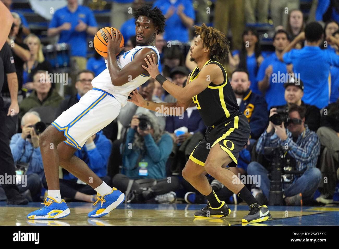 UCLA guard Eric Dailey Jr., left, backs against Oregon guard Keeshawn ...
