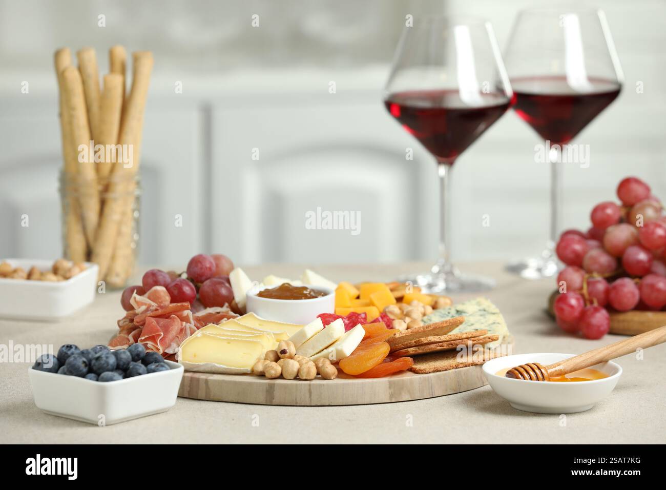 Different types of cut cheese and other snacks on light textured table ...