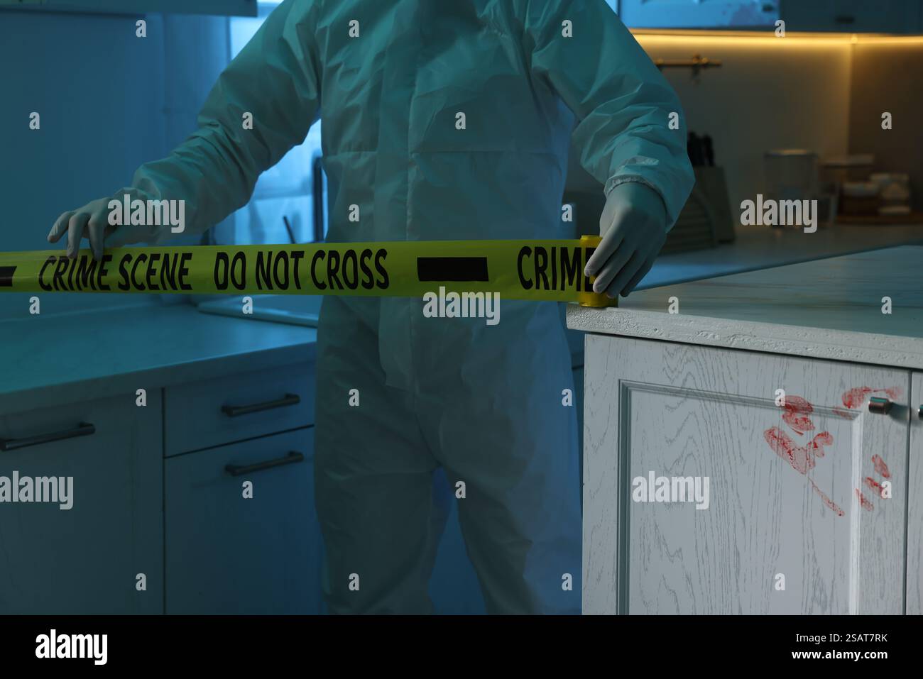 Forensic expert blocking way to crime scene with yellow tape indoors ...