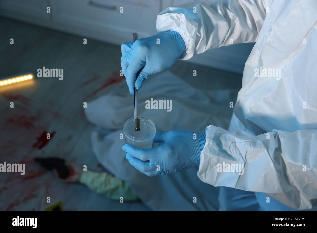 Forensic expert collecting bullet shell into container and dead body at ...