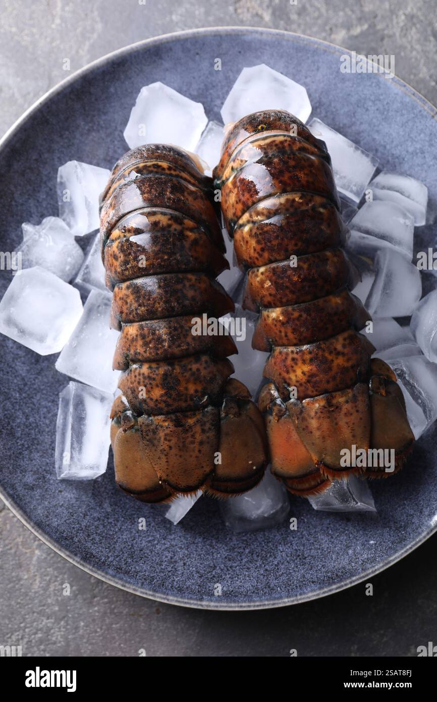 Raw lobster tails with ice on grey table, top view Stock Photo - Alamy