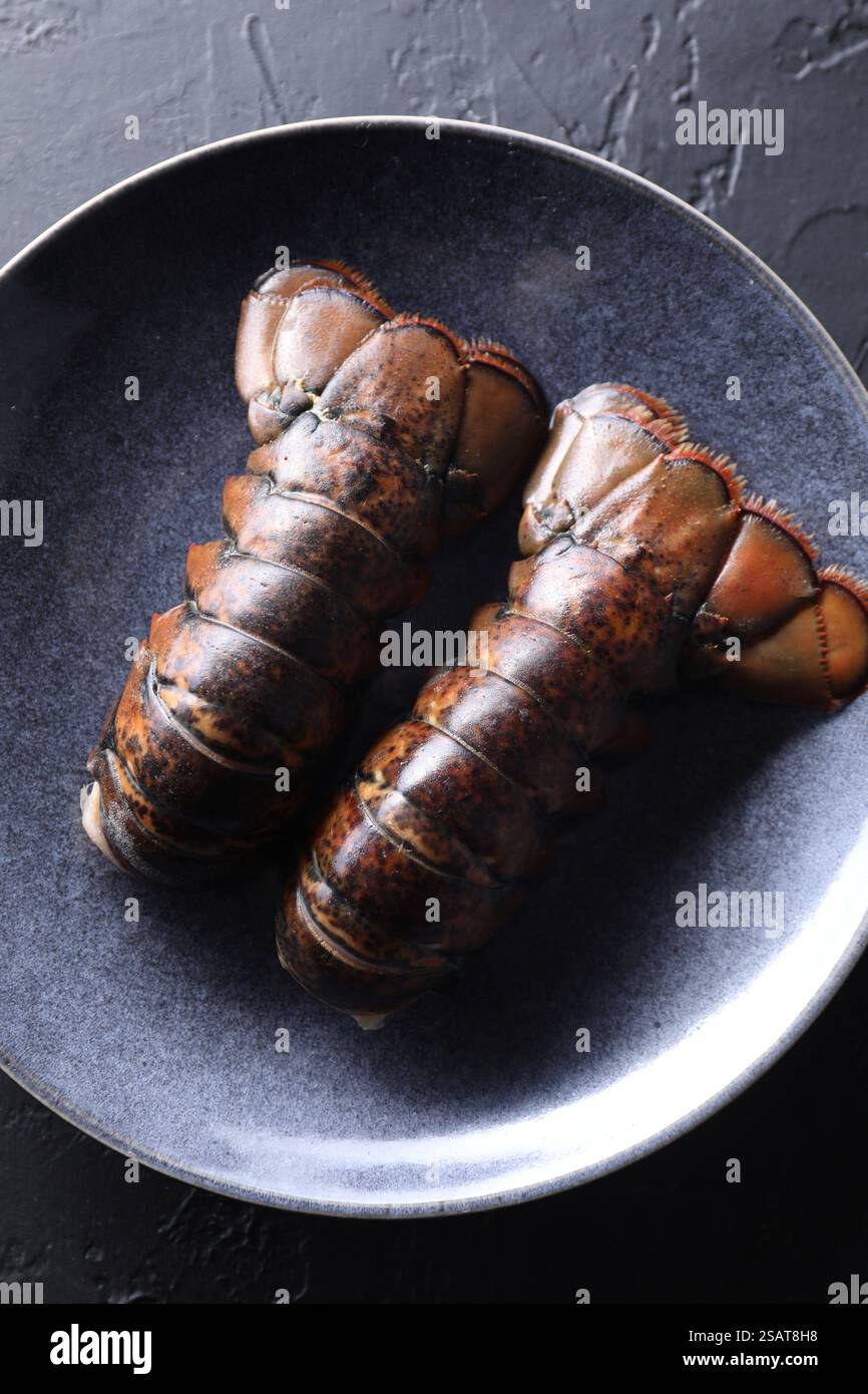 Raw lobster tails on black table, top view Stock Photo - Alamy