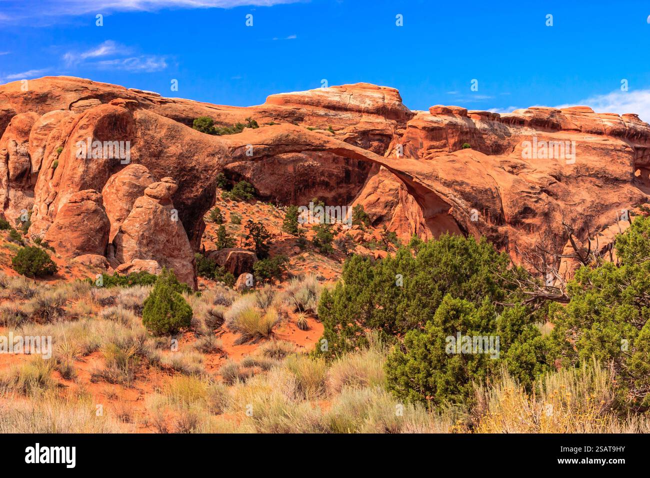 A desert landscape with a bridge over a canyon. The bridge is arched ...