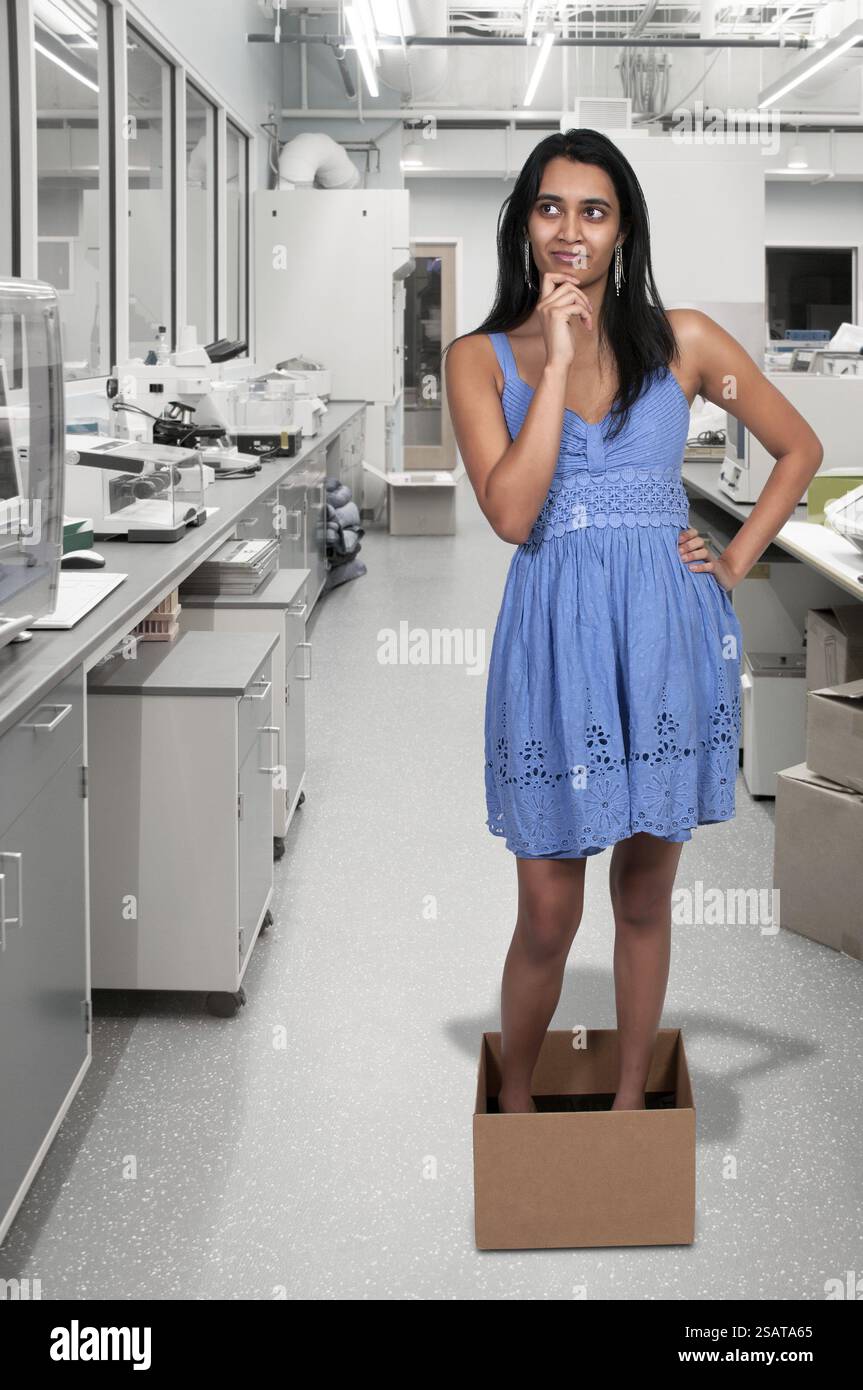 Beautiful woman thinking while standing inside a box Stock Photo - Alamy