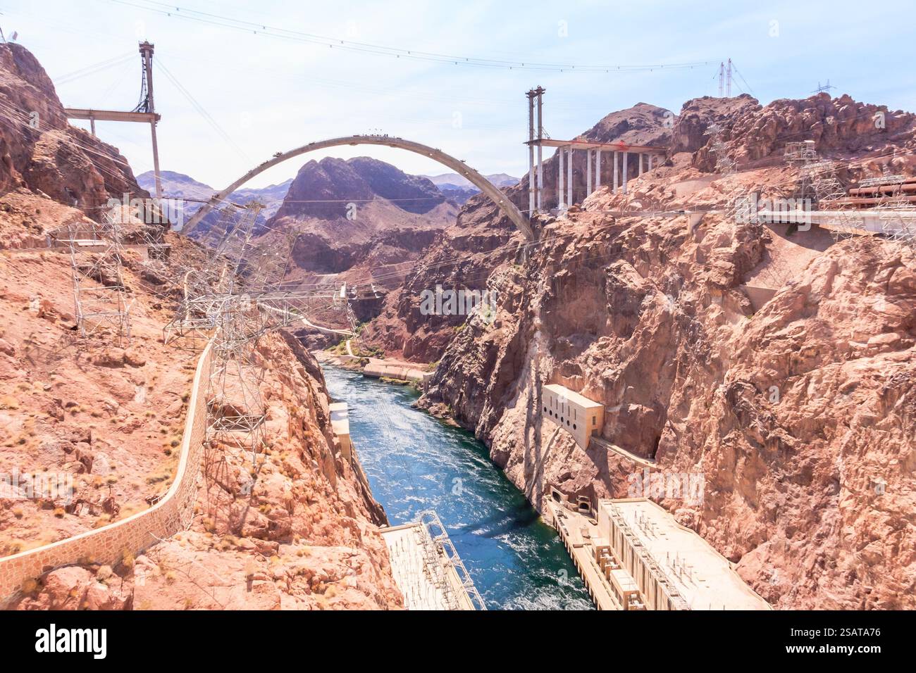 A large suspension bridge spans a river in the desert. The bridge is a ...