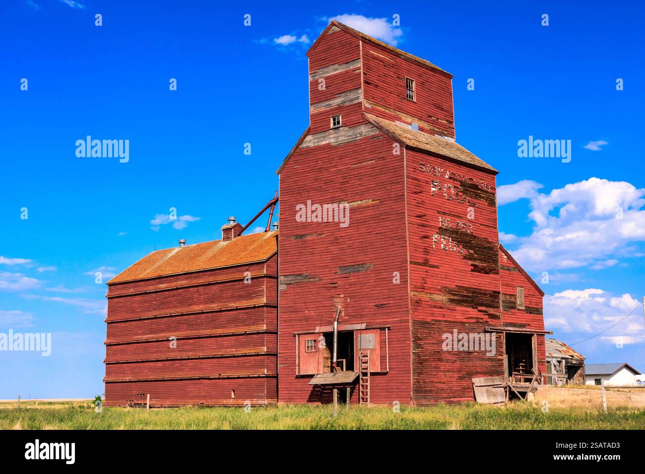 A red grain silo with a blue sky in the background. The silo is old and ...
