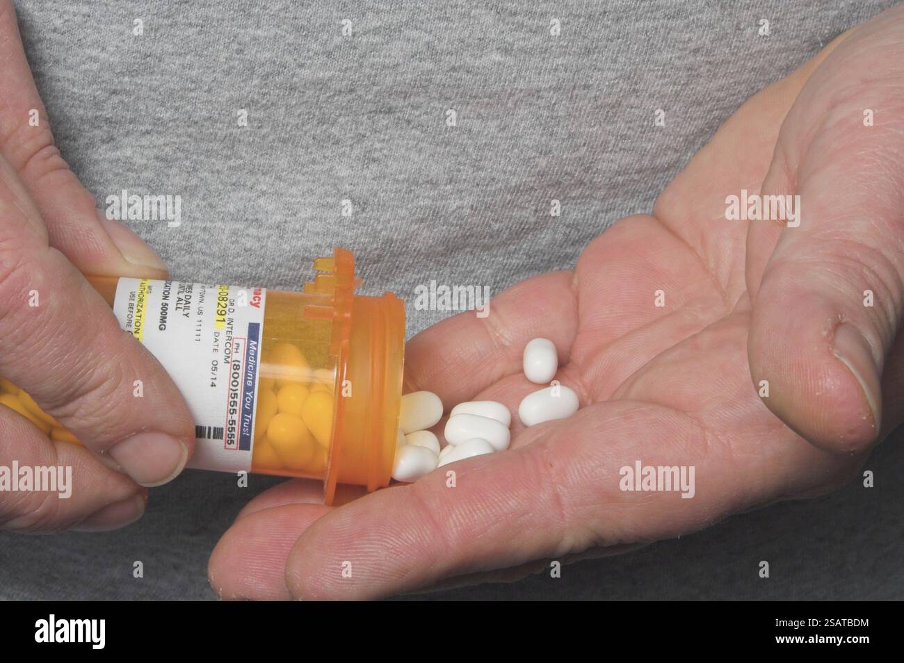 A person taking prescription medication from a bottle Stock Photo - Alamy