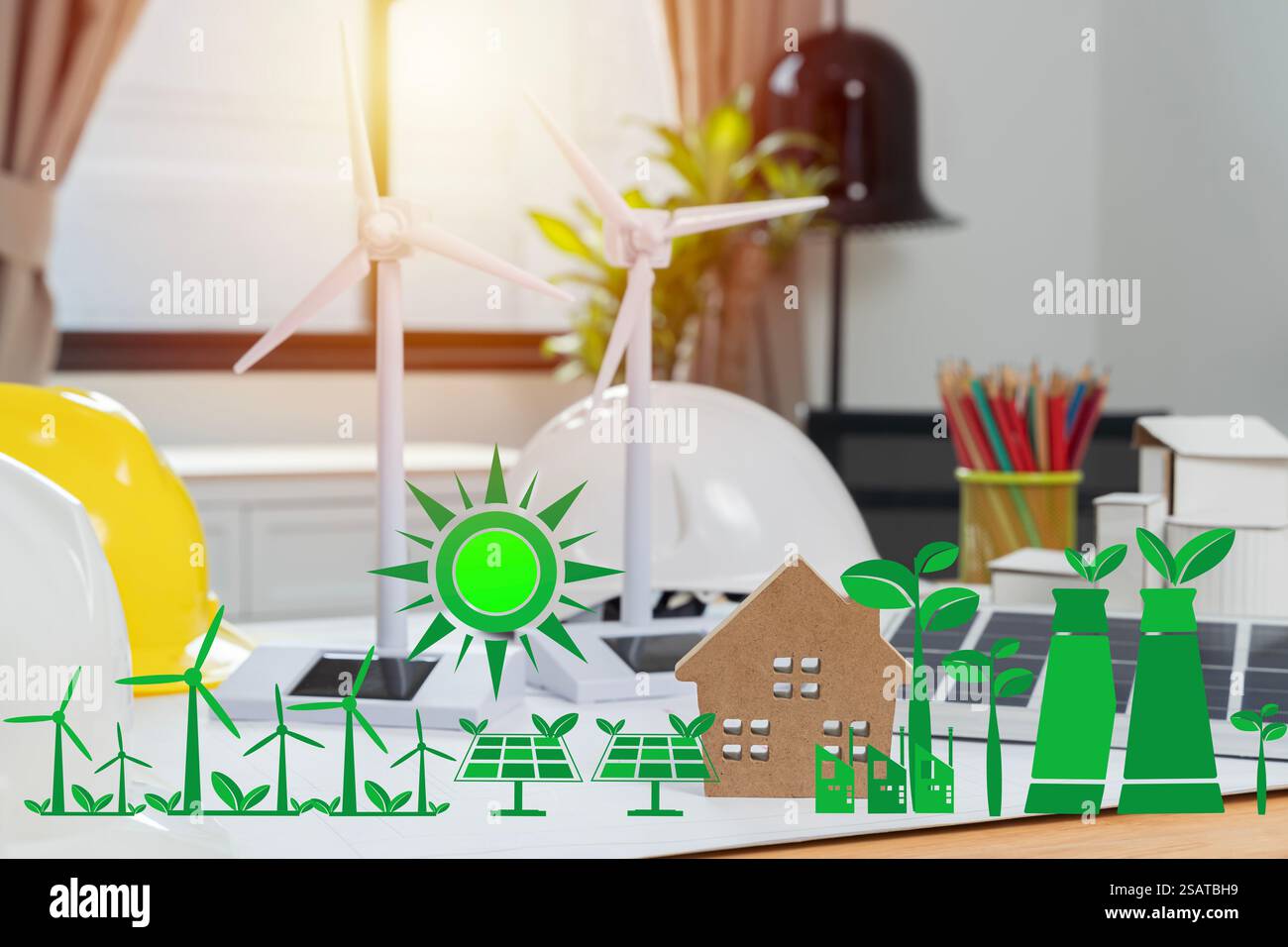 Engineer with wind turbine model sitting at desk in office ...