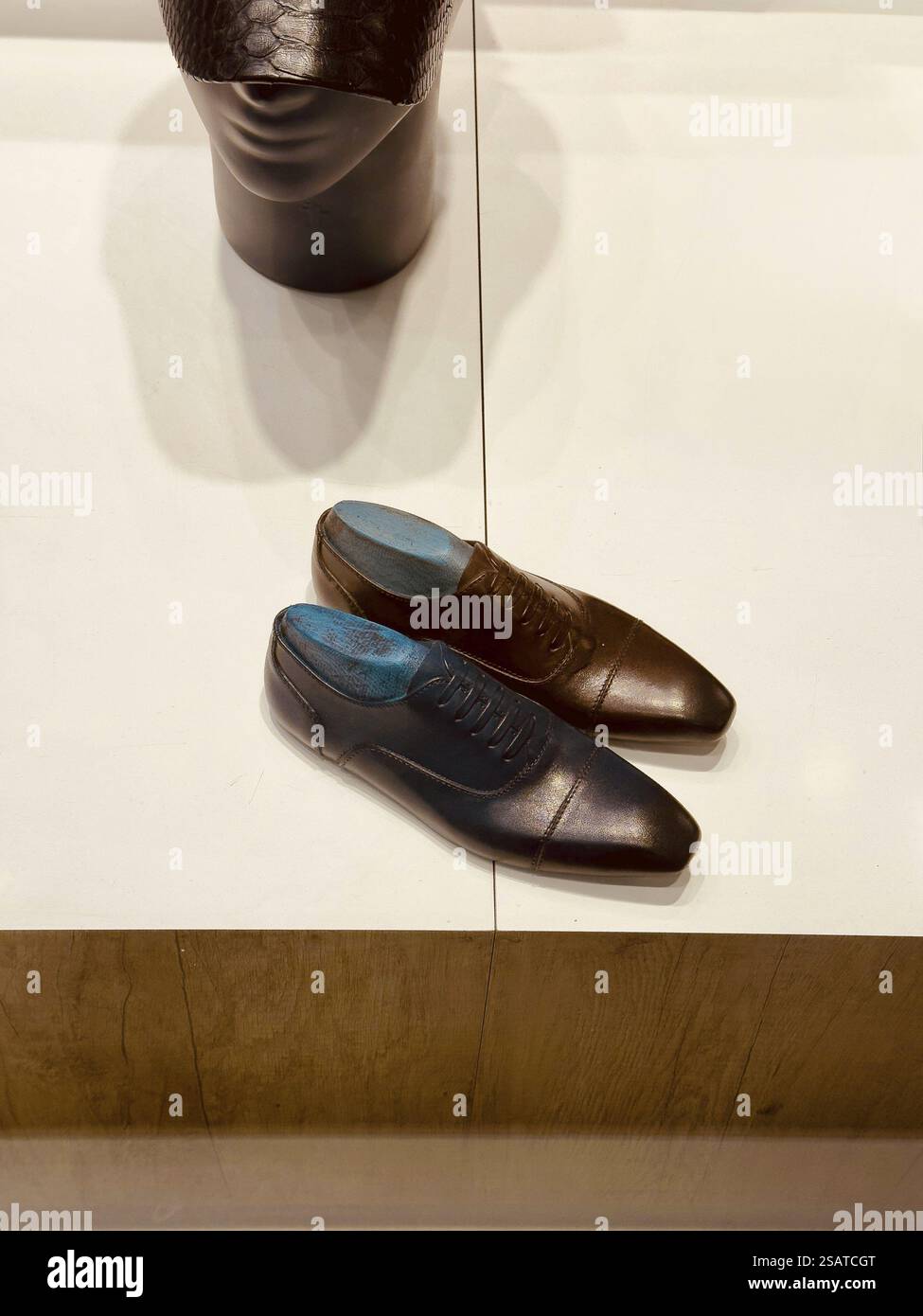 Two leather shoes with blue inner soles on display in a stylish store ...