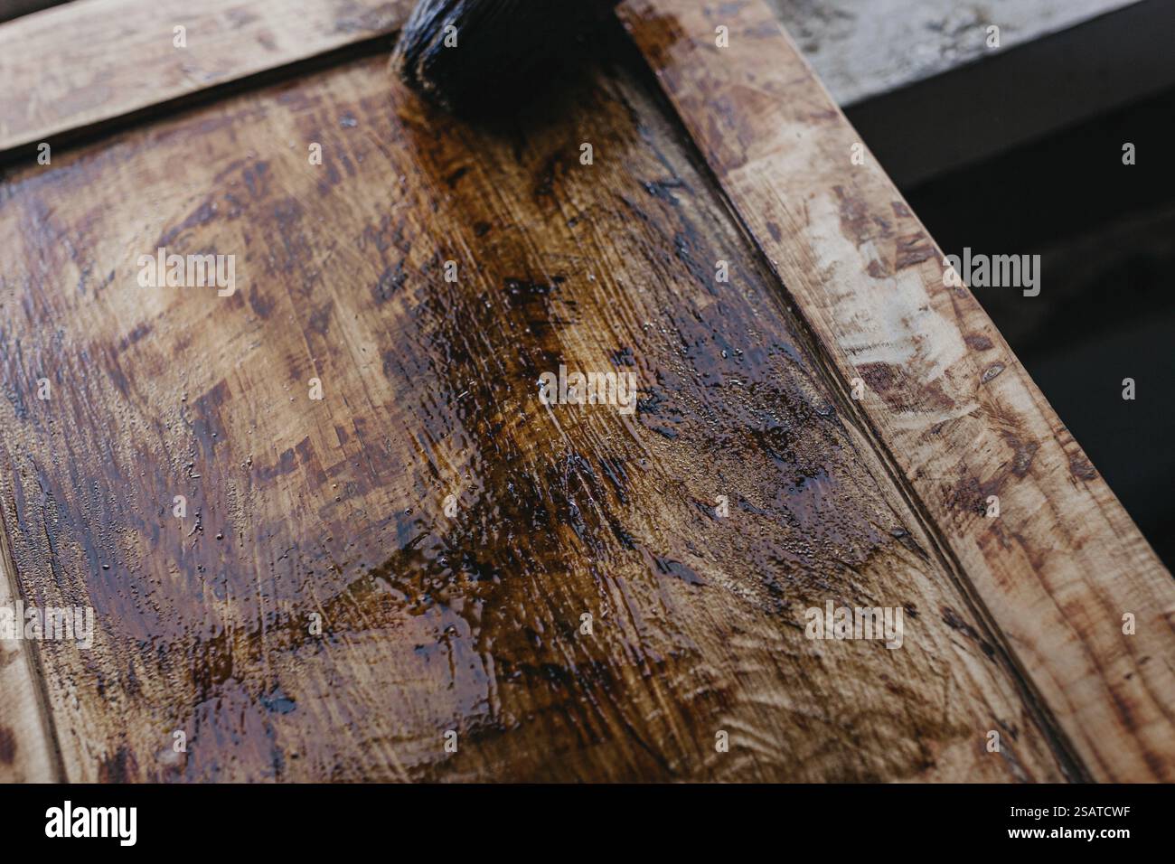 Varnished wood surface showing rich texture and grain in dark tones ...
