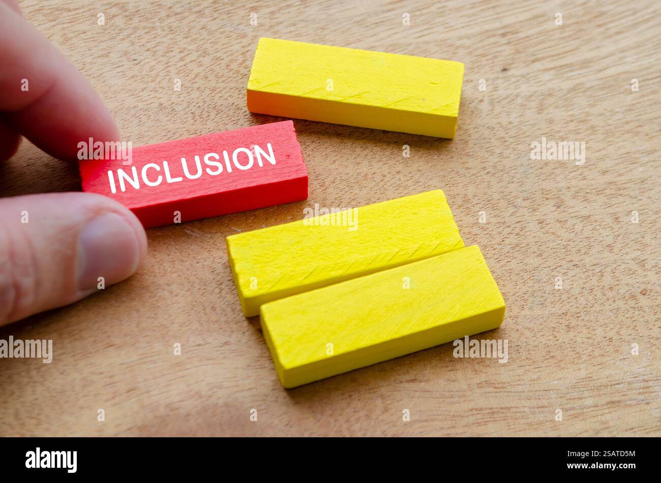 Hand placing Inclusion text with the rest of yellow wooden blocks . D ...