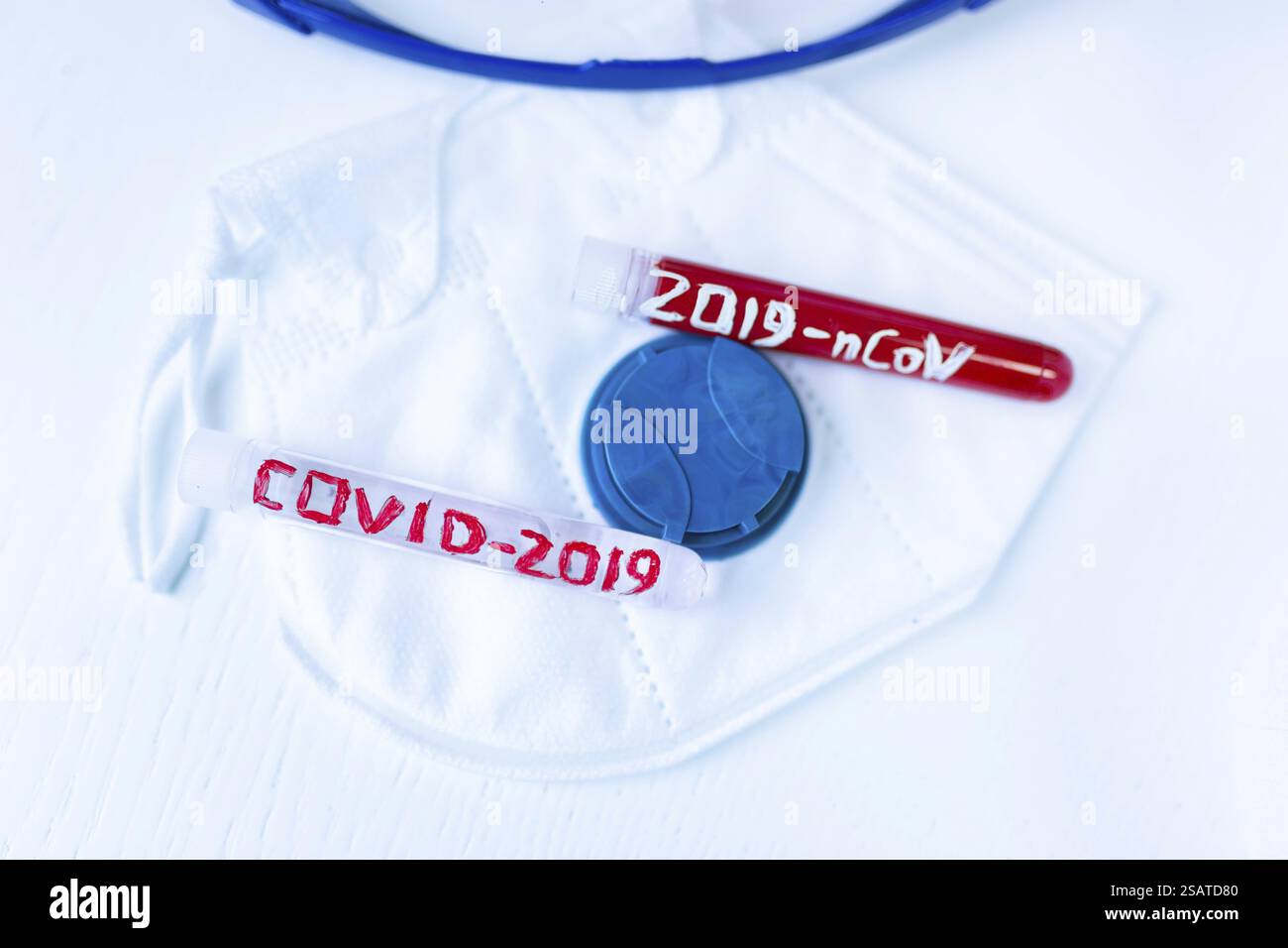 Test tubes labeled 2019-nCoV and COVID-2019 with face mask and cap ...