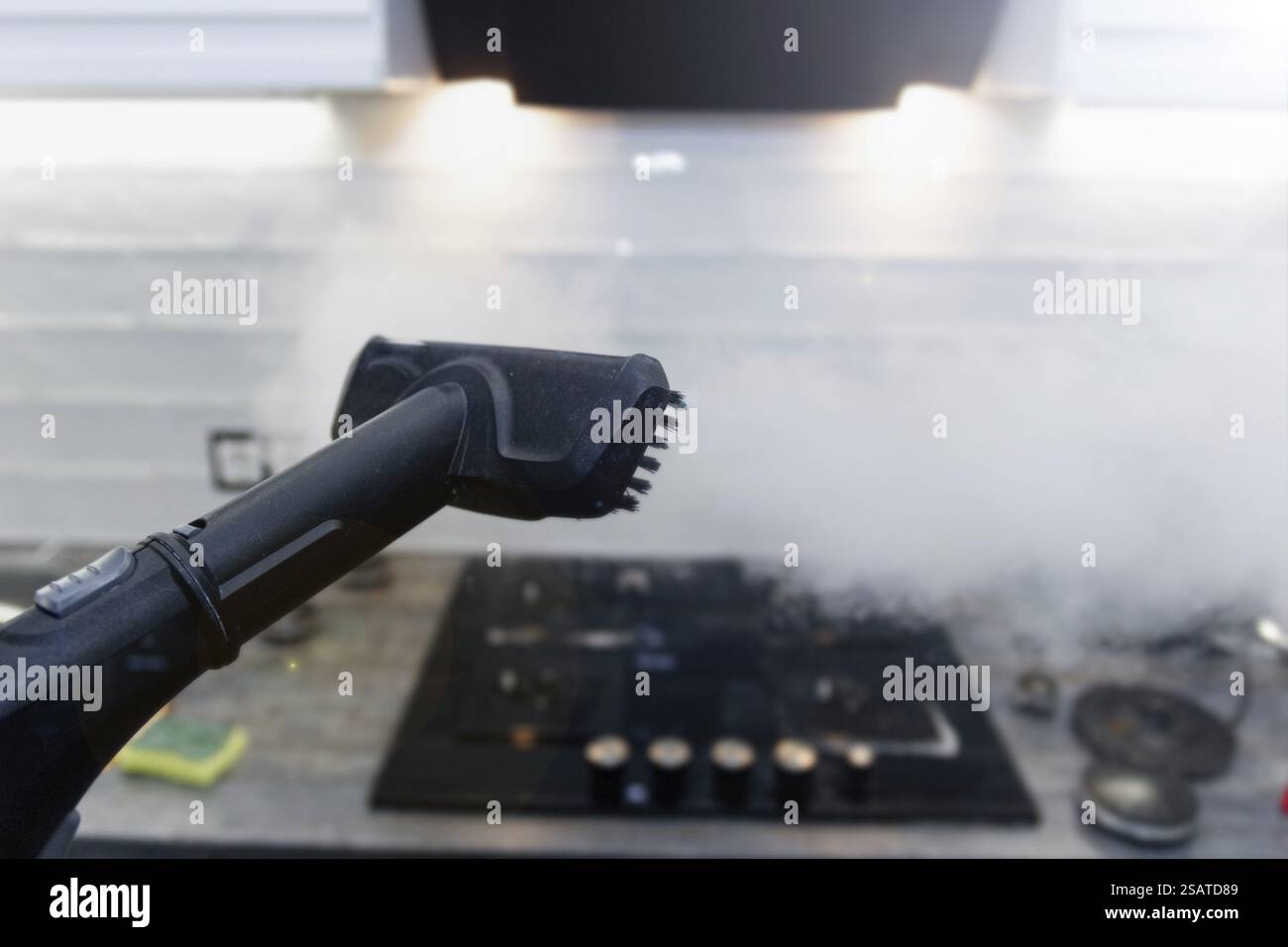 Nozzle emitting steam over stovetop with illuminated backsplash in ...