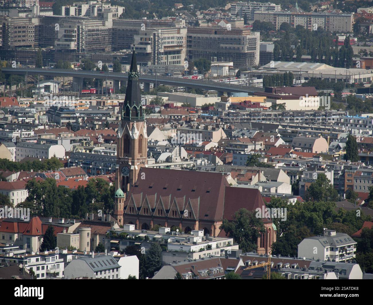 Church tower towers over the city, surrounded by modern buildings ...
