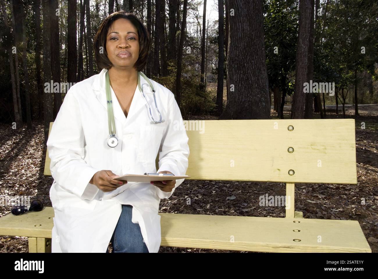 A female African American doctor sitting on a bench Stock Photo - Alamy