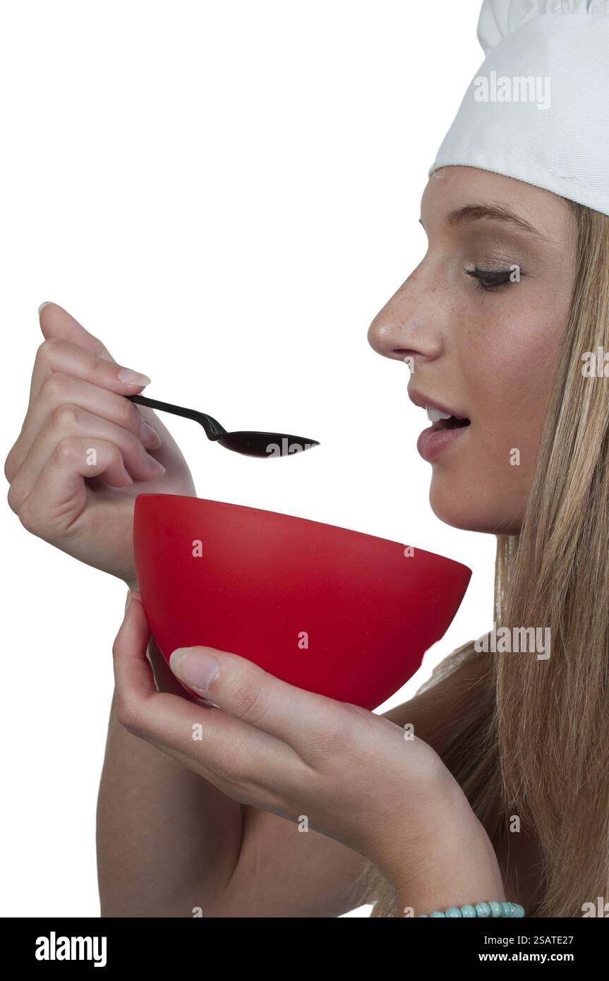A beautiful woman chef eating food from a bowl Stock Photo - Alamy
