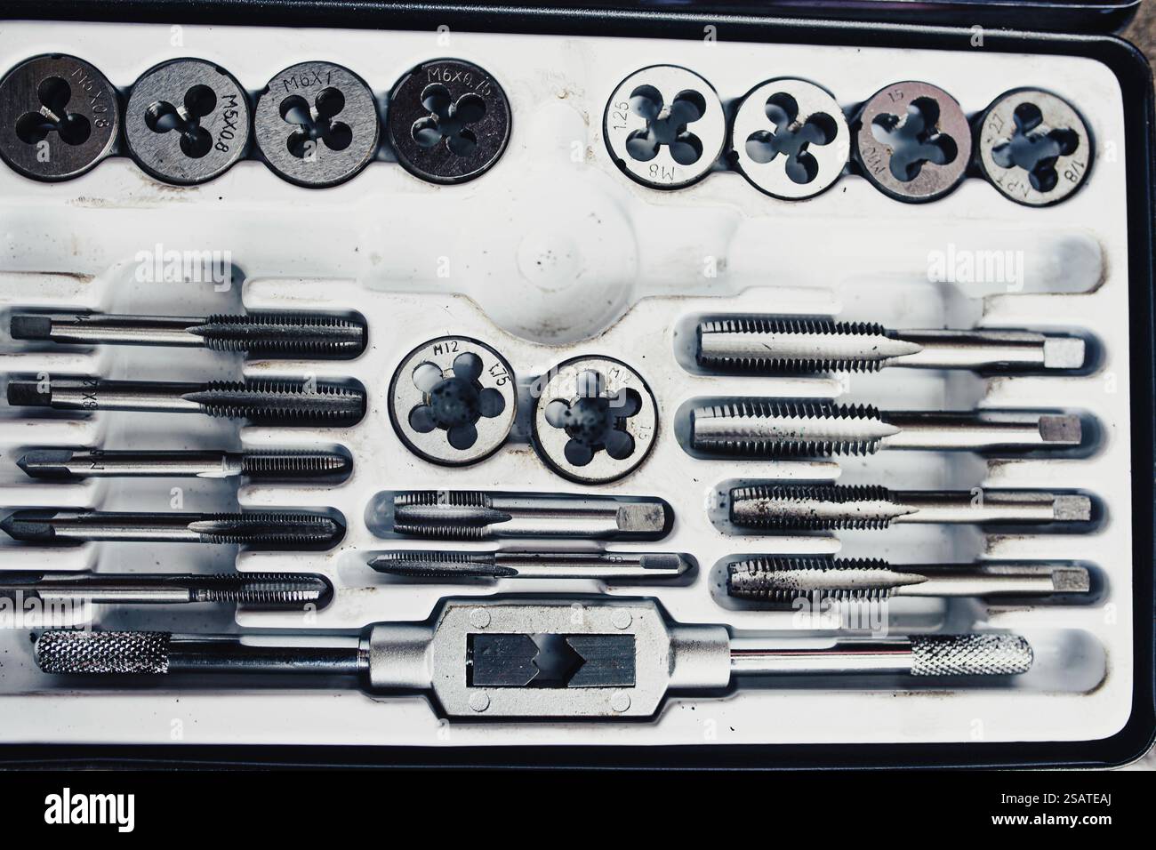 Close-up of a detailed and organized tap and die set featuring various ...