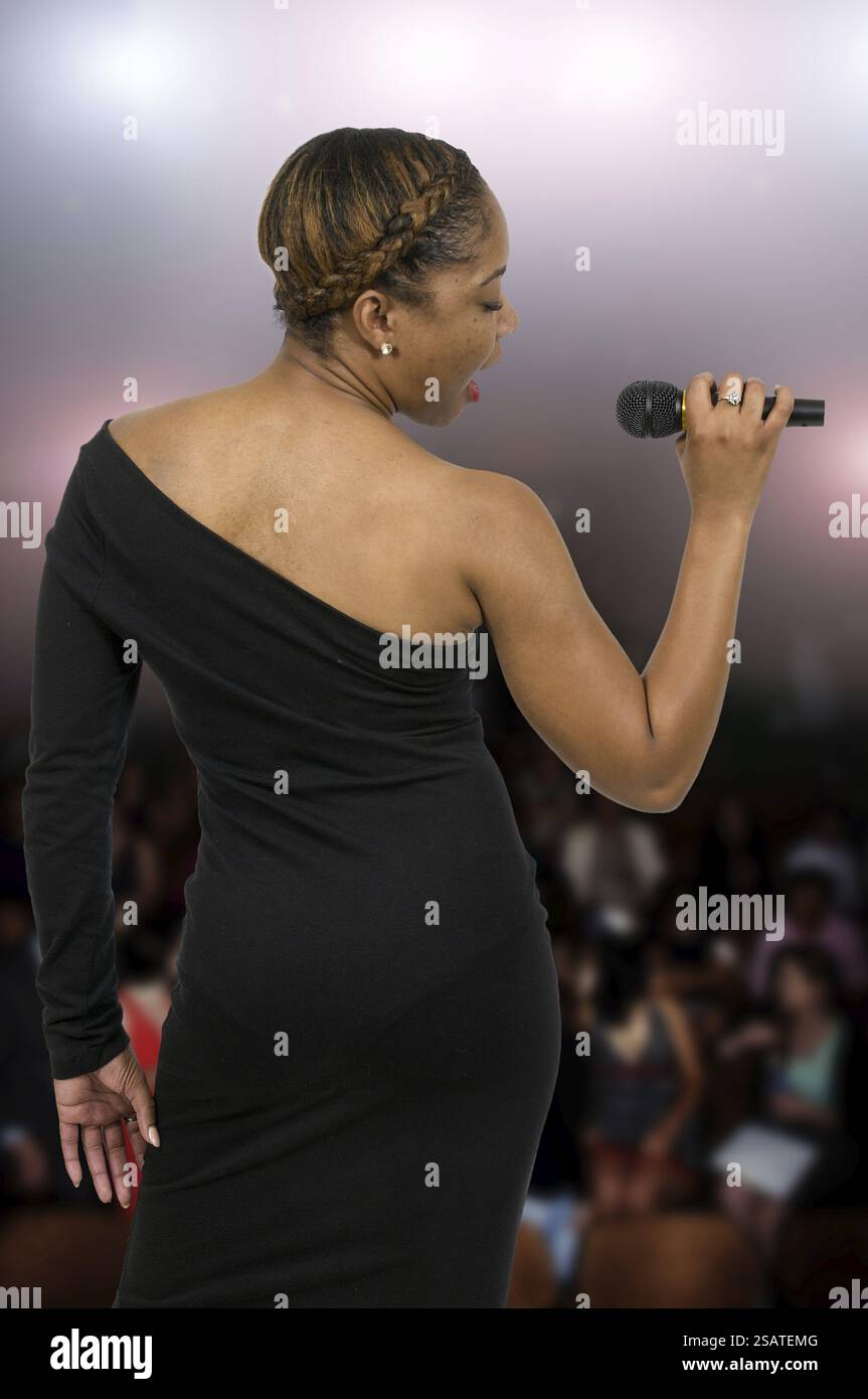 Beautiful woman singer performing at a concert Stock Photo - Alamy