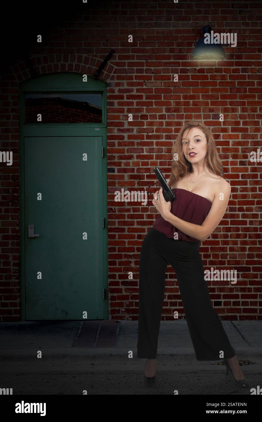 Beautiful woman with a loaded handgun pistol Stock Photo - Alamy