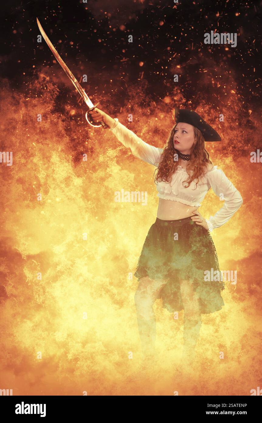 Young beautiful pirate woman with cutlass saber sword in a fire Stock ...