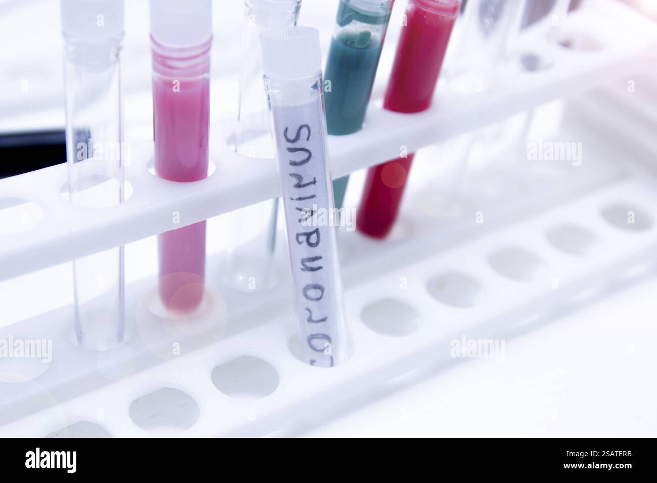 Rack of colorful test tubes with one labeled 'coronavirus' in a lab ...