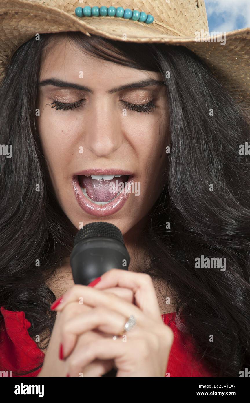 Beautiful woman singer performing at a concert Stock Photo - Alamy