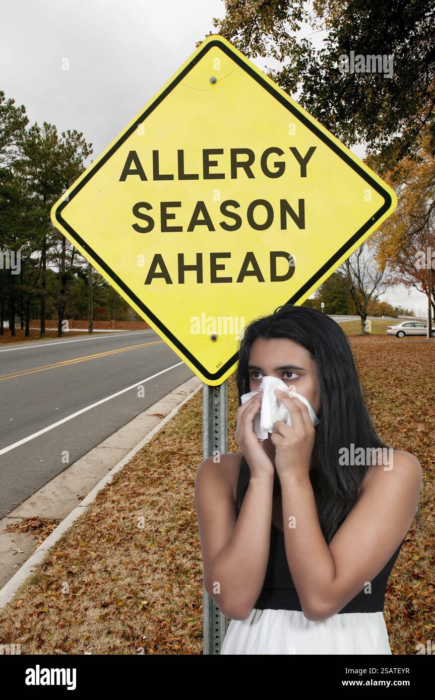 Beautiful woman with a cold, hay fever or allergies blowing her nose ...