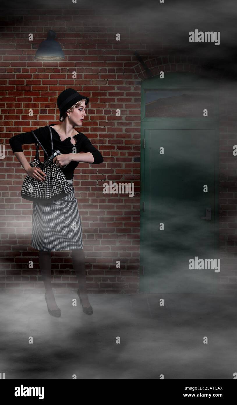 Beautiful scared woman pulling out a gun in a dark alley Stock Photo ...