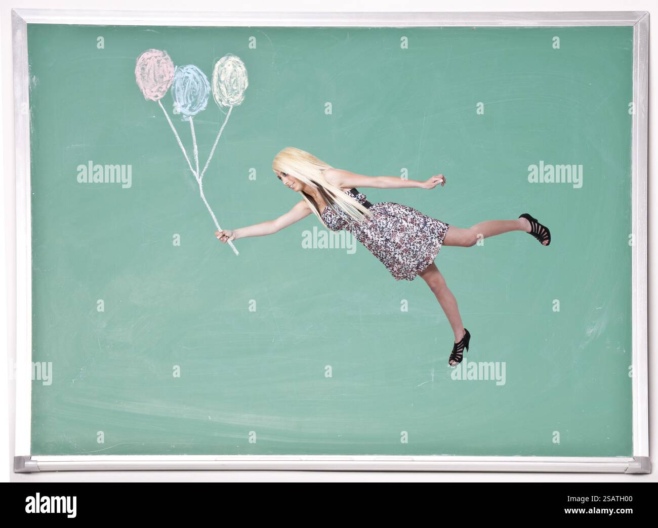 A beautiful young woman floating with balloons on a chalkboard Stock ...