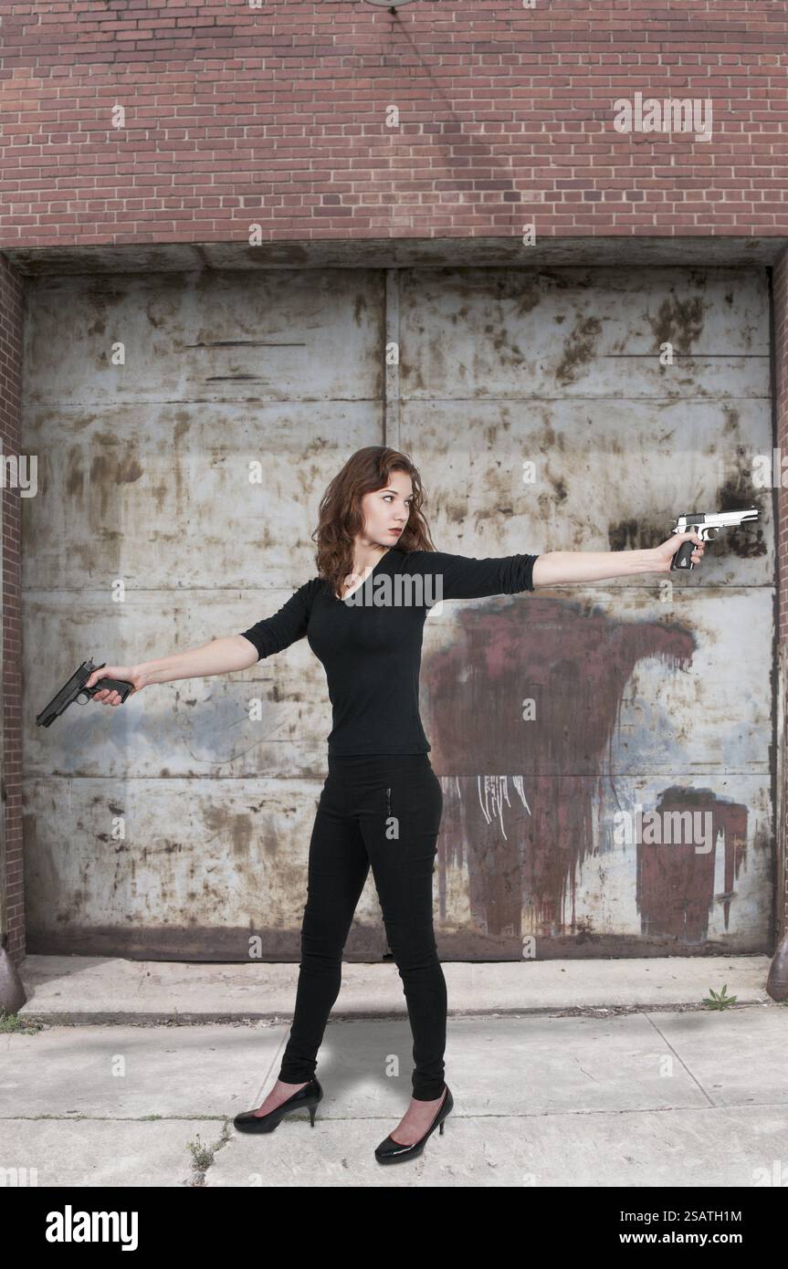 Beautiful woman with a loaded handgun pistol Stock Photo - Alamy