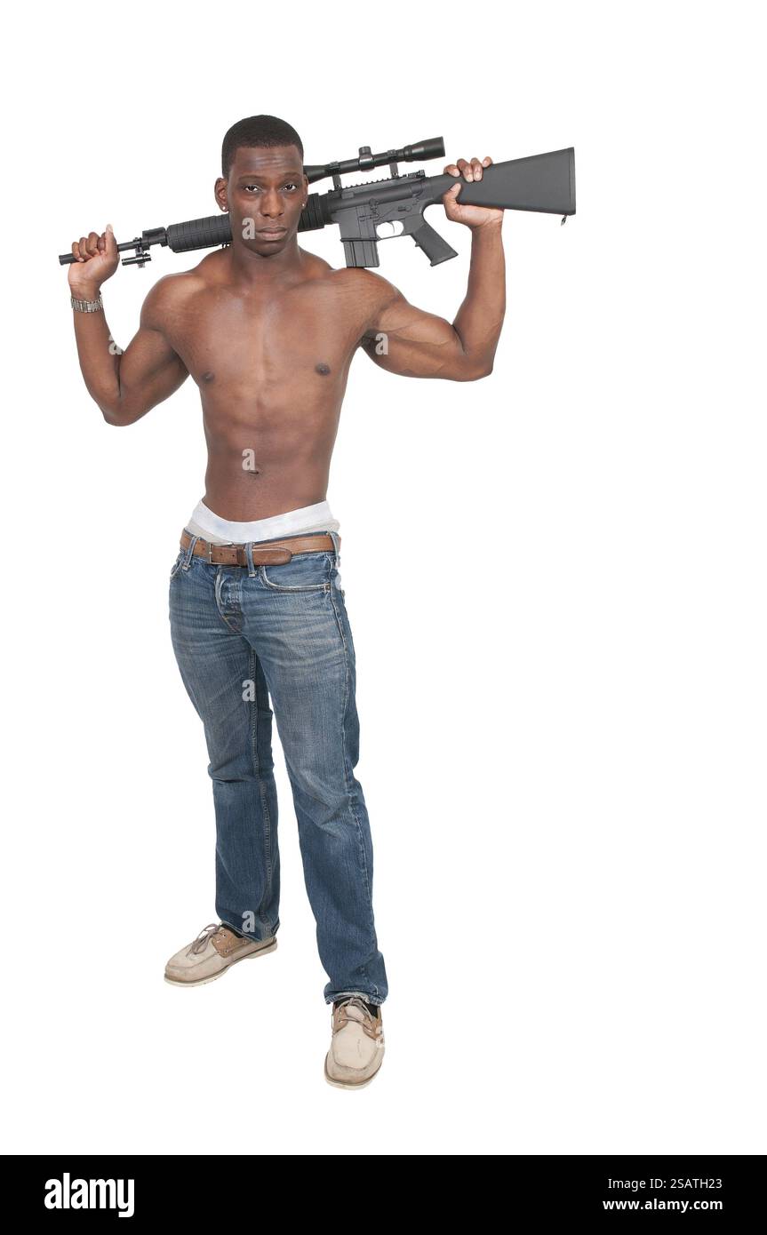 Handsome man holding an automatic assault rifle Stock Photo - Alamy