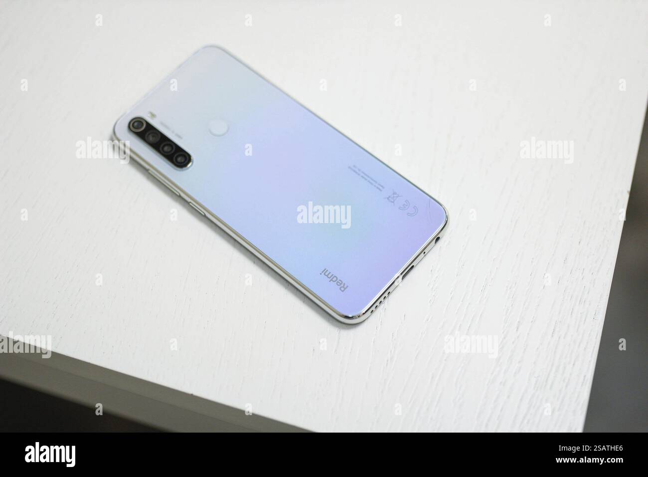 Minimal silver smartphone with quad camera setup on a flat surface ...