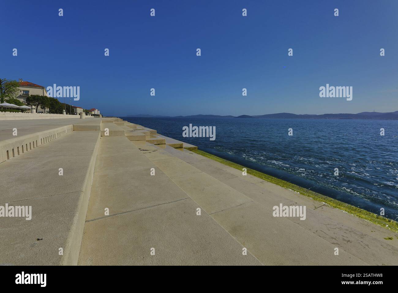 Coastal steps lead to the sea with a wide view of the blue expanse and ...
