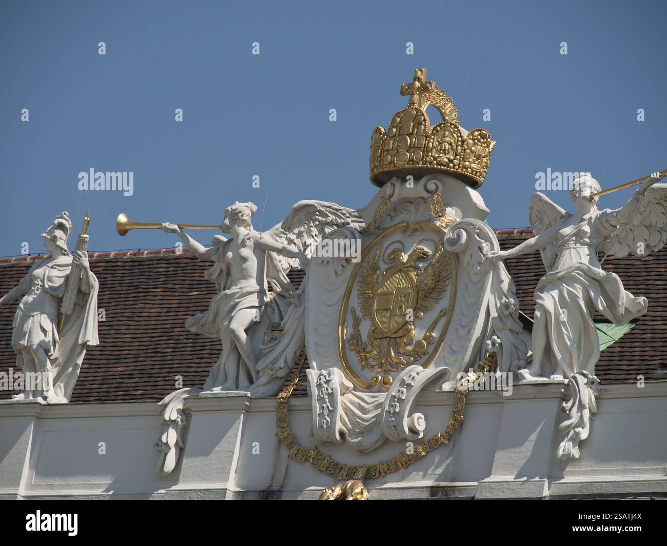 Detail of a baroque facade with sculptures and golden crown, richly ...