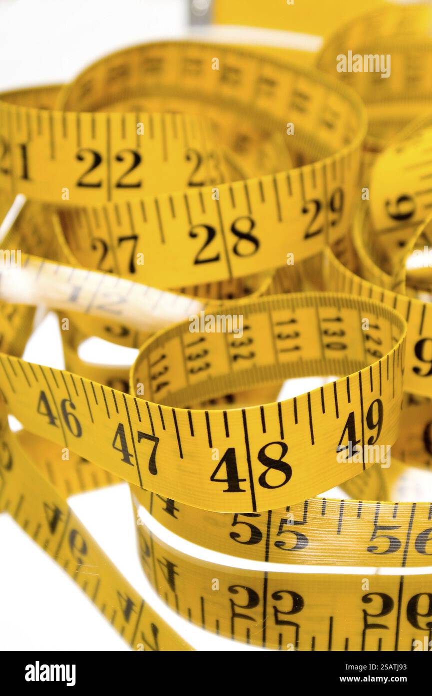 A tailor's measuring tape coiled up randomly Stock Photo - Alamy