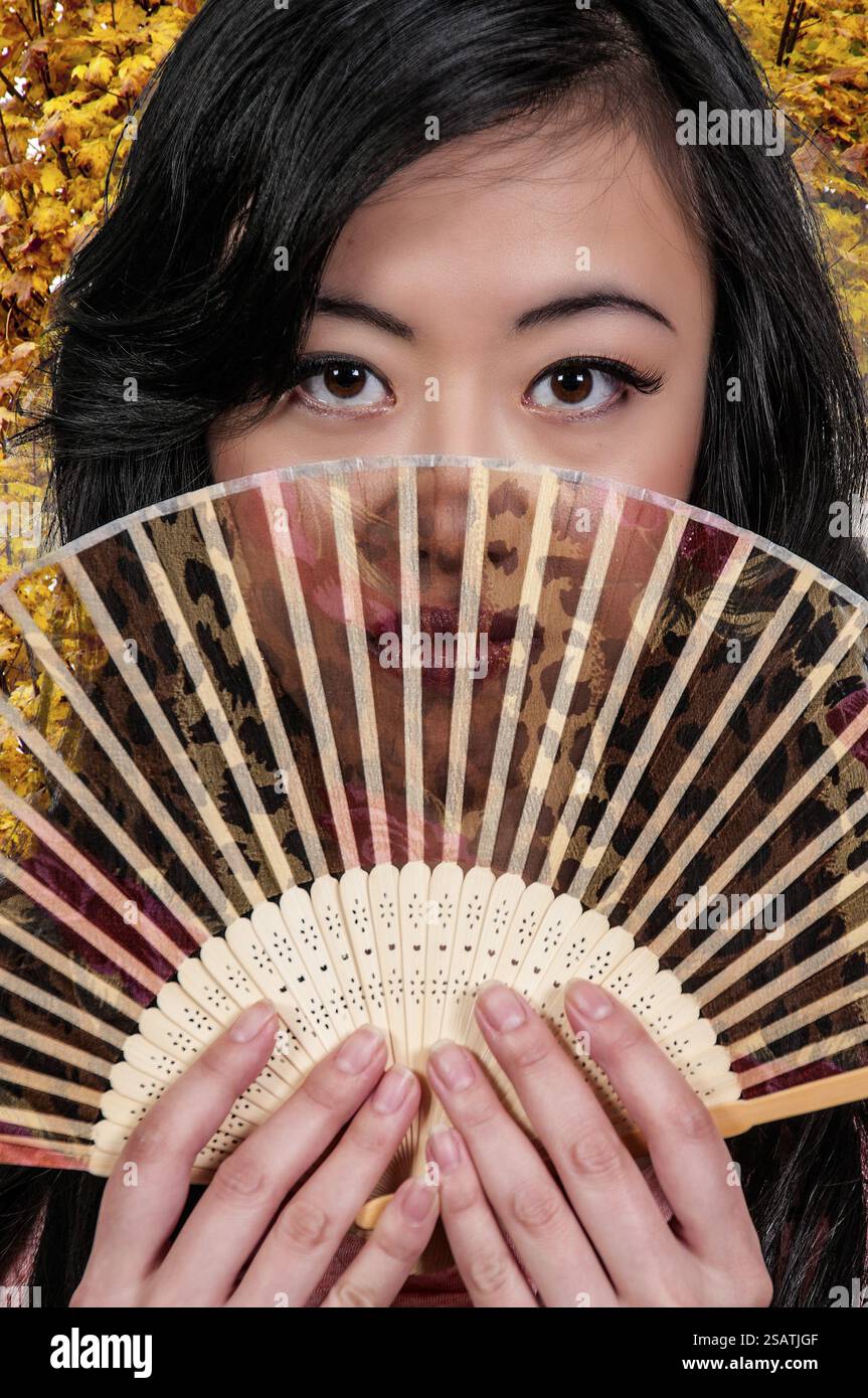Beautiful woman holding a traditional oriental fan Stock Photo - Alamy