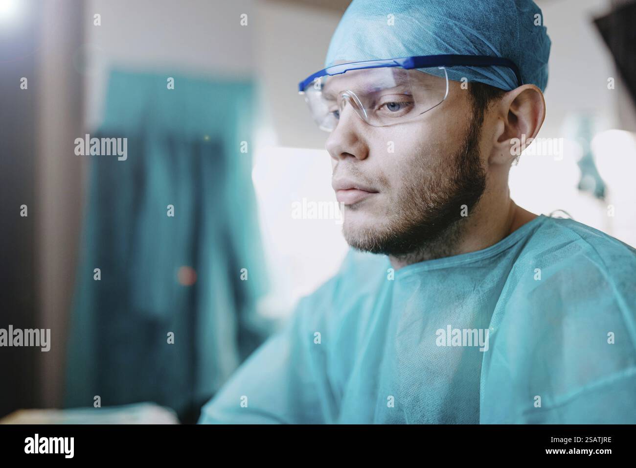 A medical staff member in blue scrubs, appearing calm and concentrated ...