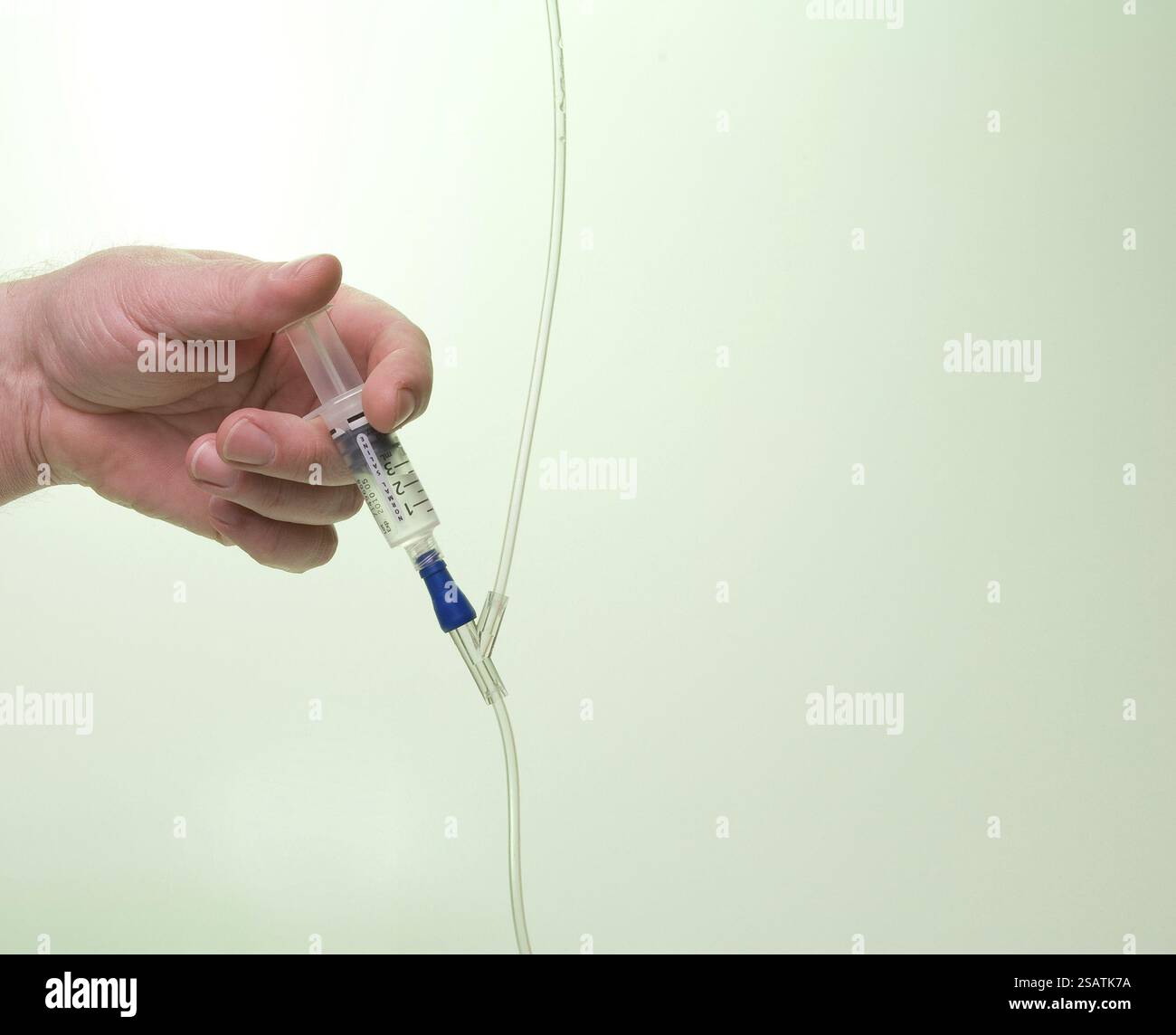 A hospital worker using a saline flush in an IV tube Stock Photo - Alamy