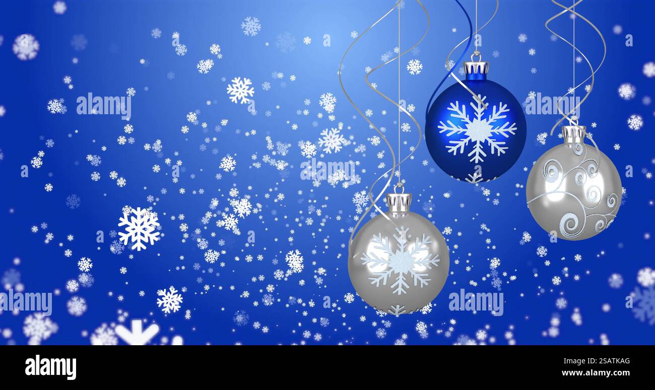 Image of christmas baubles over snow falling Stock Photo - Alamy