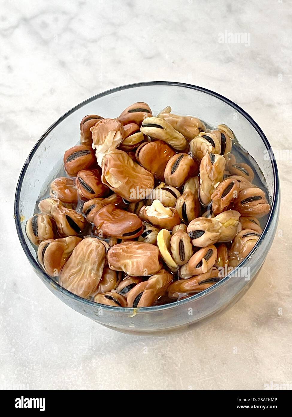 Soaked beans in water in glass bowl on marble table. Food and healthy ...