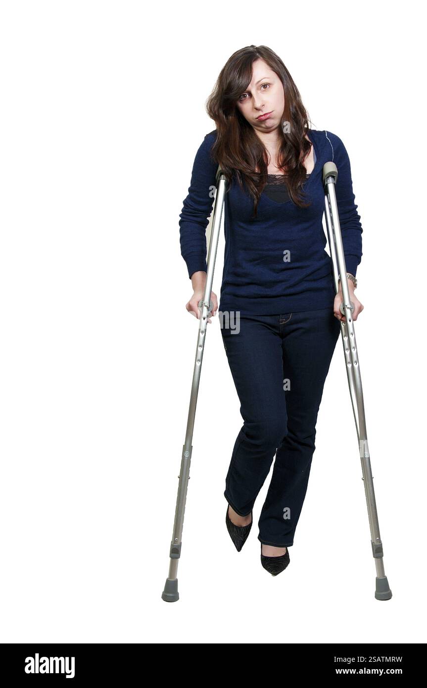 A beautiful woman using a set of medical crutches to help her walk ...