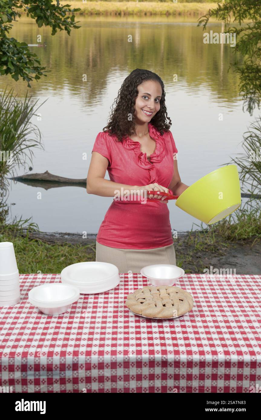 Beautiful woman organising a checkered picnic table Stock Photo - Alamy