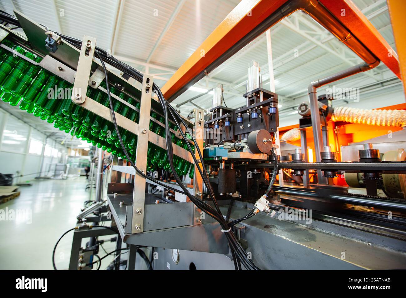 Bottling line in a factory showcasing machinery and green bottles in ...